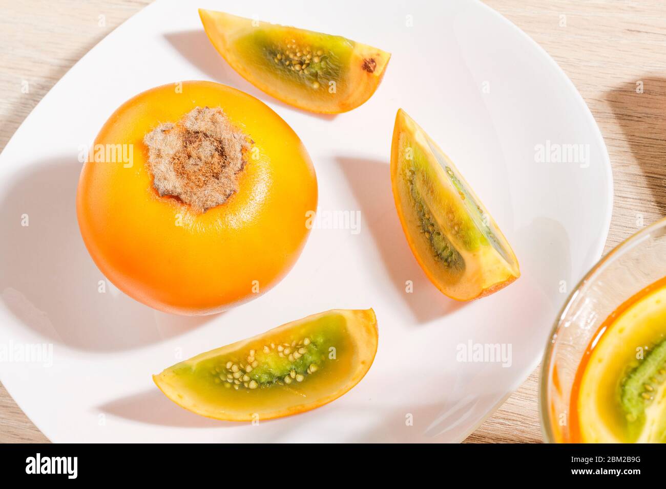 glass with juice and slices of lulo fruit, on the table, Solanum ...