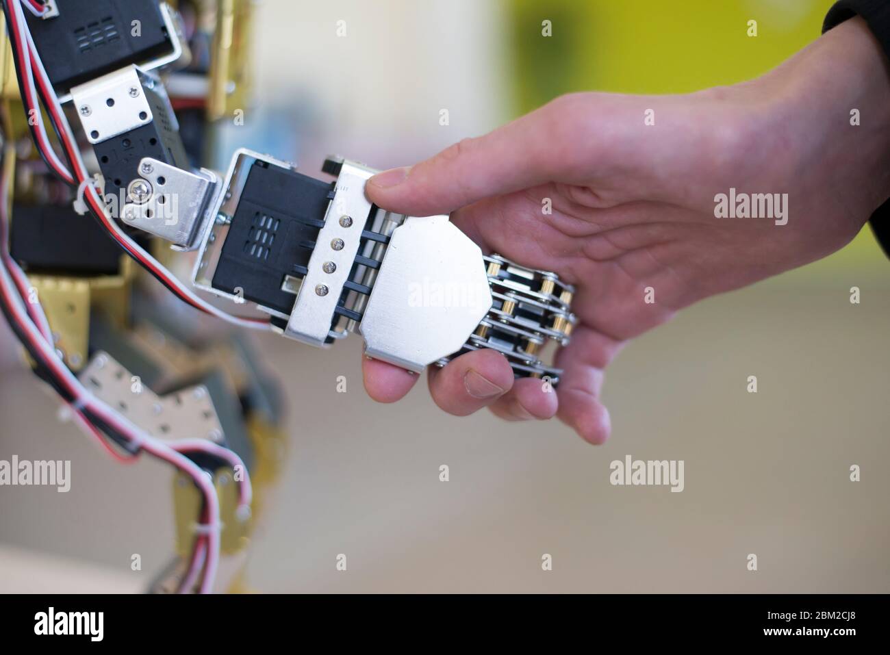 Photo of a human hand holding a robot hand with a handshake Stock Photo ...
