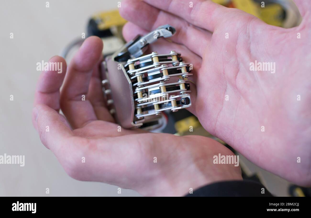 Photo of a human hand holding a robot hand Stock Photo - Alamy
