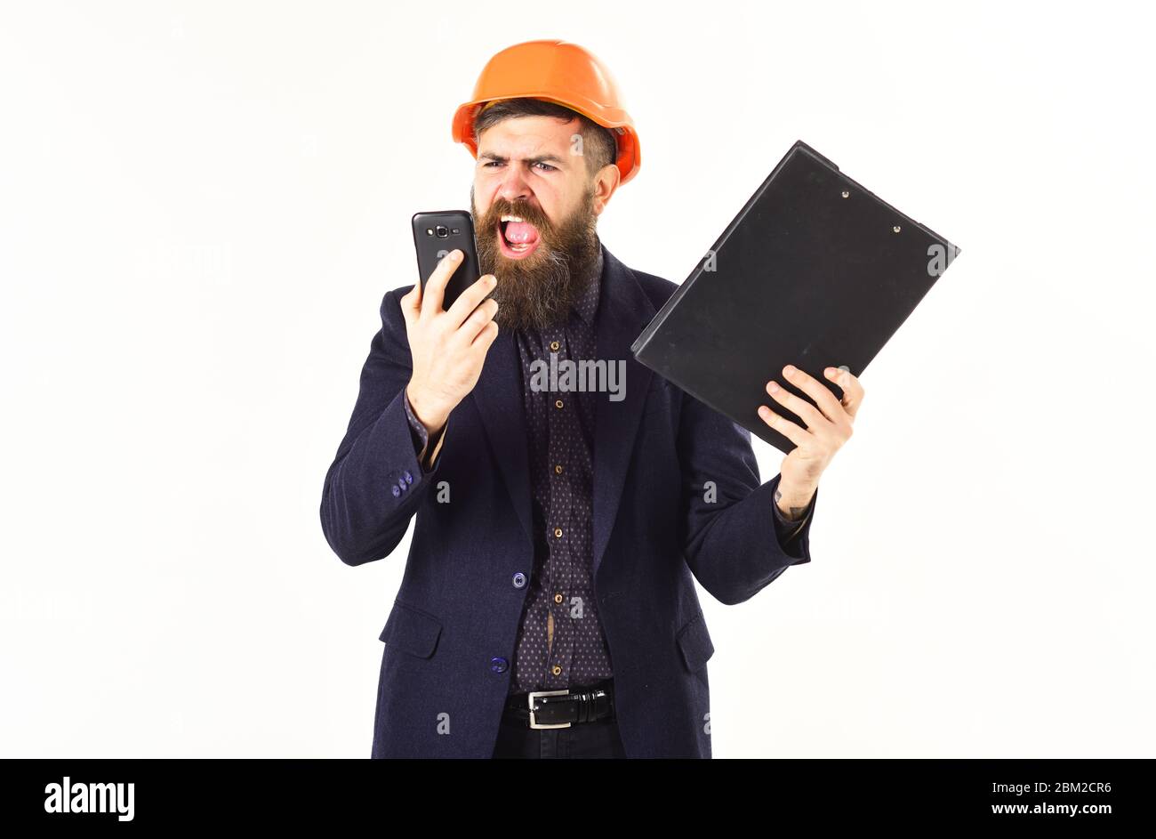 Angry face concept. Architect with angry face shouts and holds mobile ...