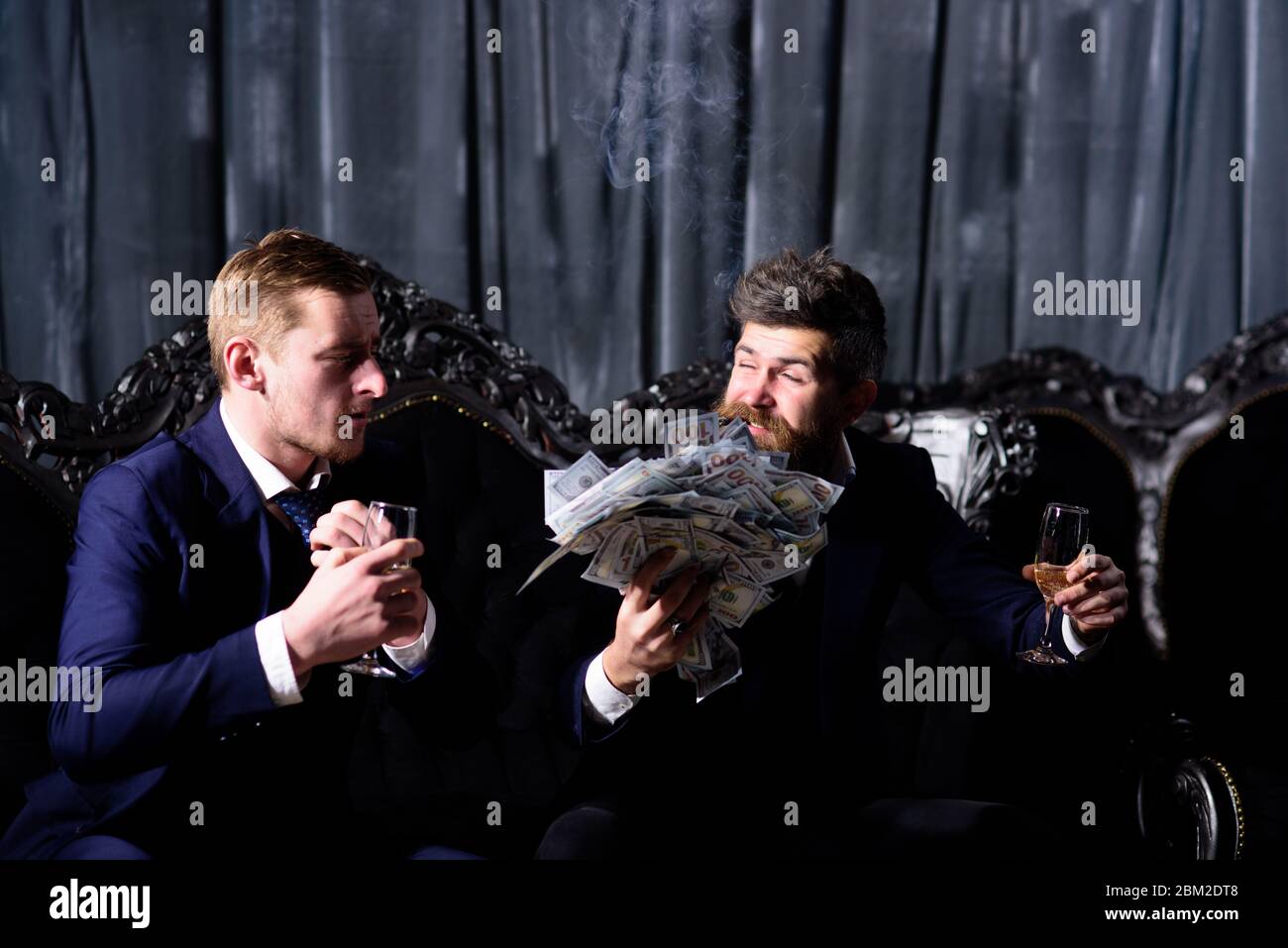 Luxury life concept. Men in suit, businessmen sit in dark luxury ...