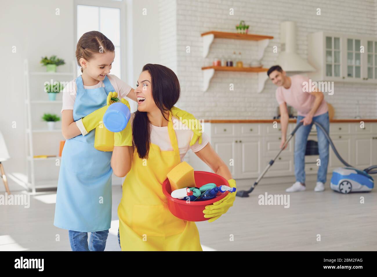 Happy family cleans the room in the house. Mother father and little ...