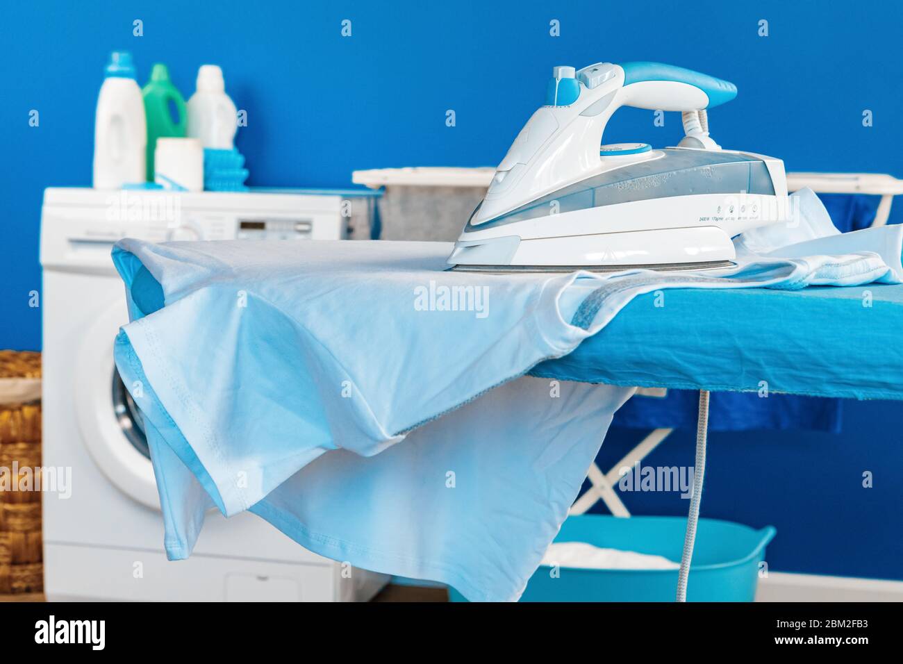 Housekeeping concept. Washing machine and ironing board Stock Photo - Alamy