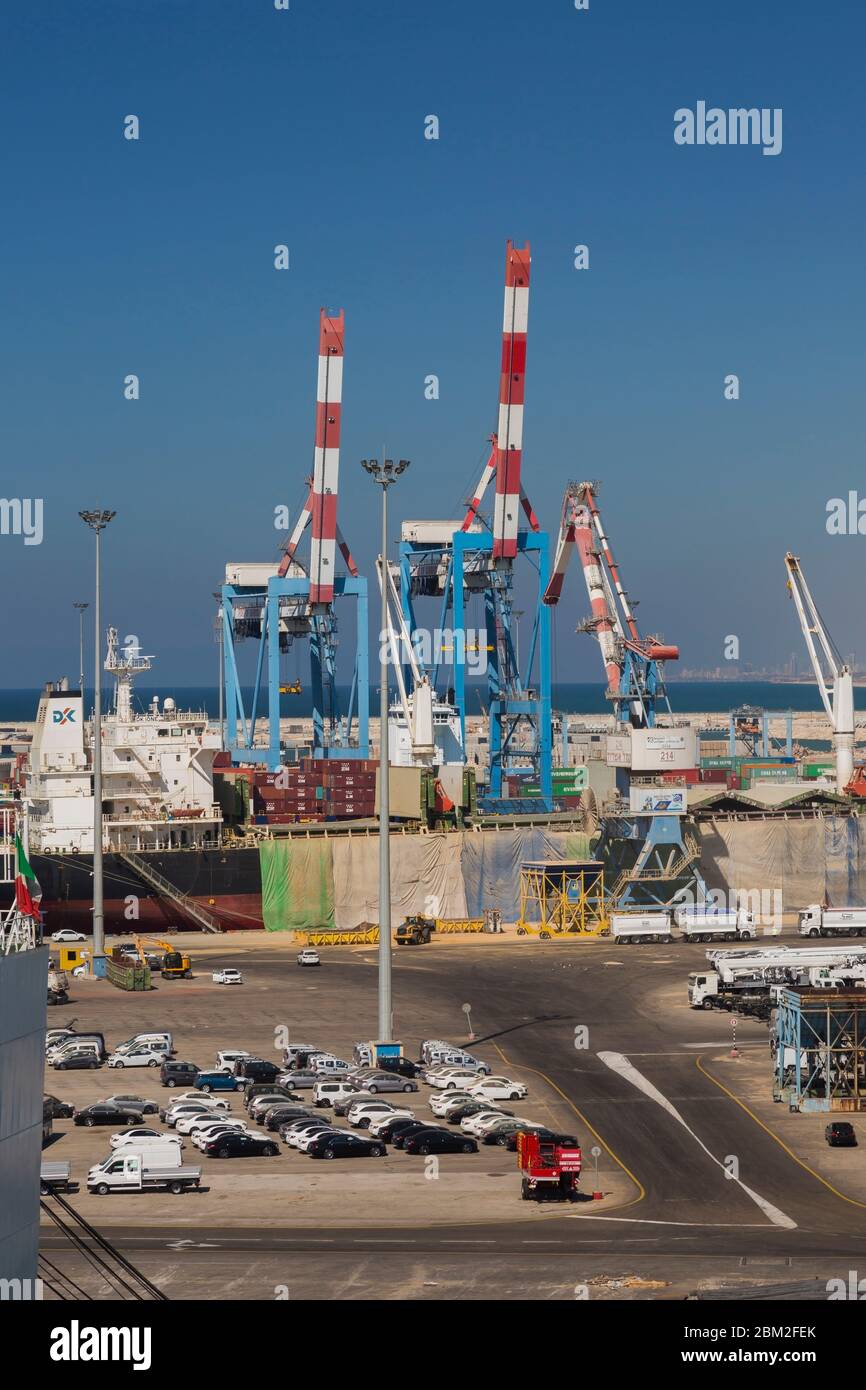Dock with parked motor vehicles ready for shipping plus docked cargo ...