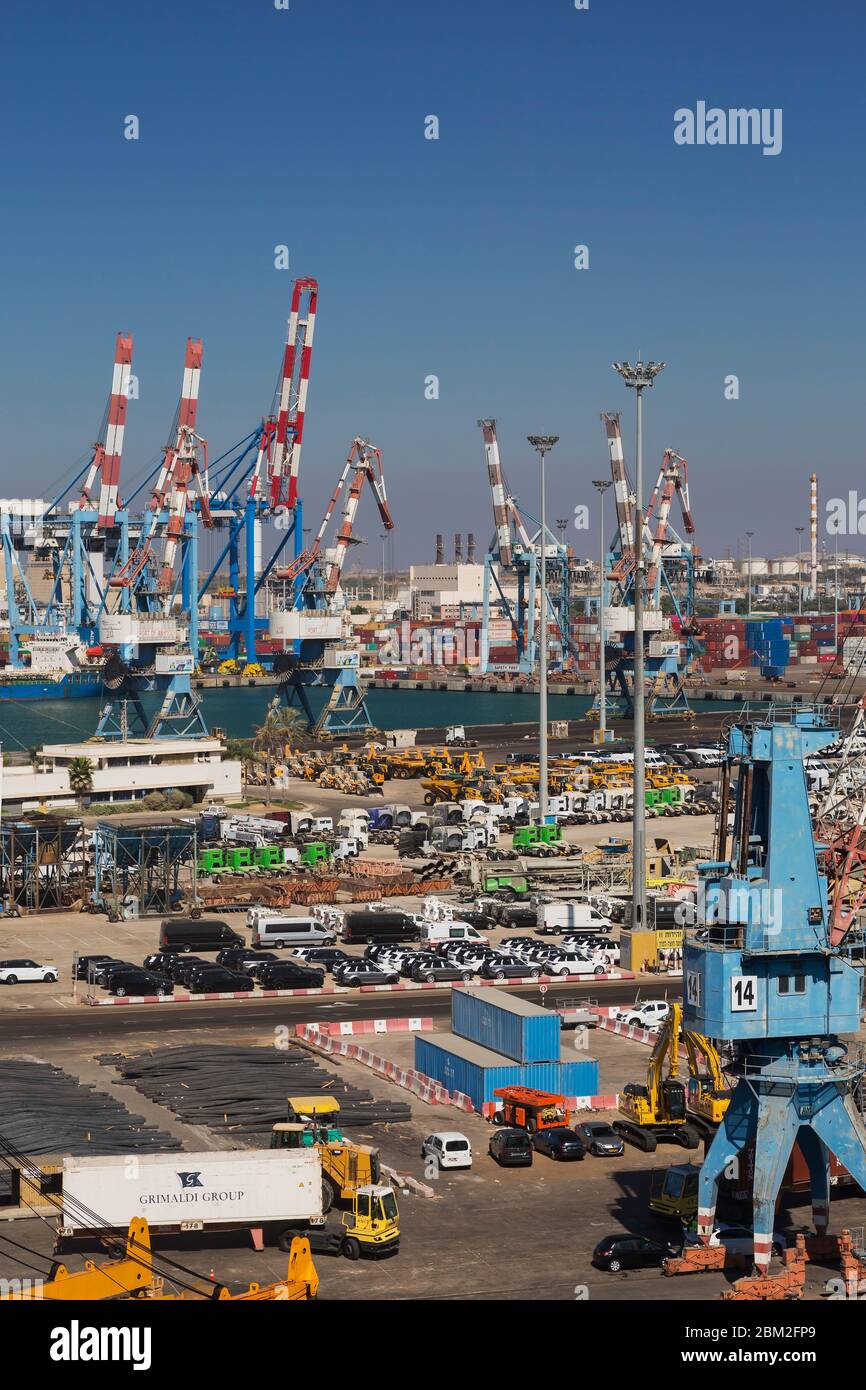 Four-link cargo loading crane on dock with parked motor vehicles ready ...