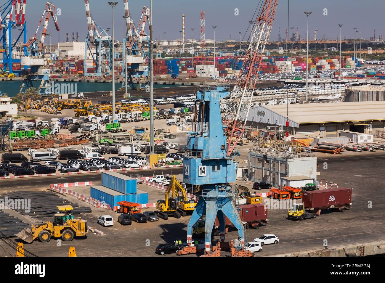 Four-link cargo loading crane on dock with parked motor vehicles ready ...