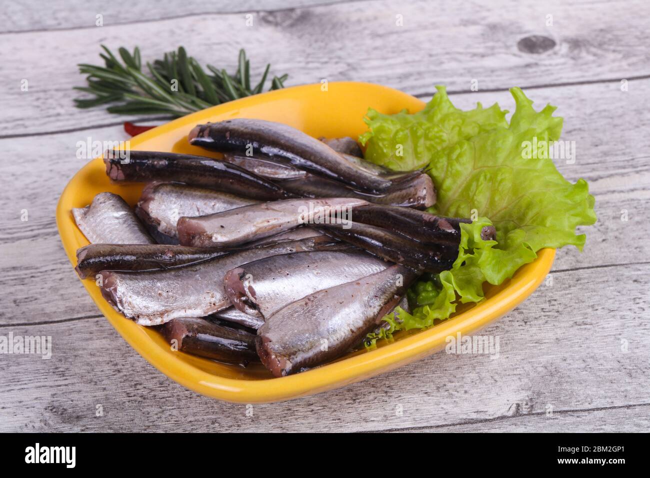 Anchovy fish snack in the bowl served salad leaves and rosemary Stock ...