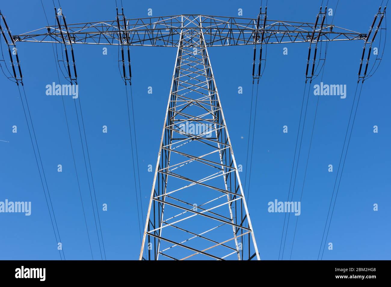 Electricity pylon in the middle from below under a blue sky Stock Photo ...