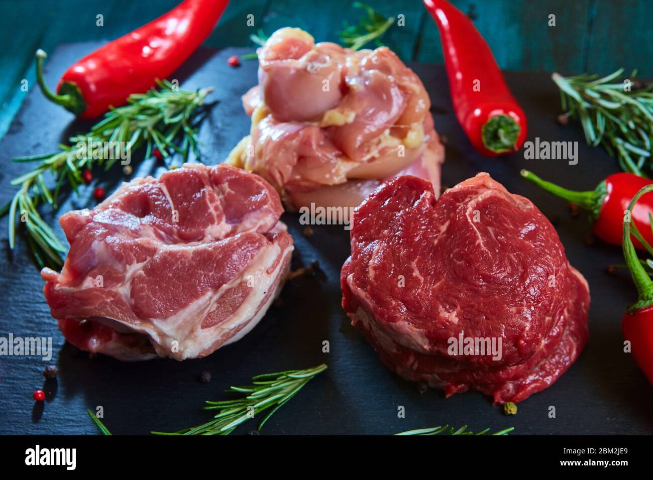 Fresh three types of meat chicken, pork and beef on black stone with ...