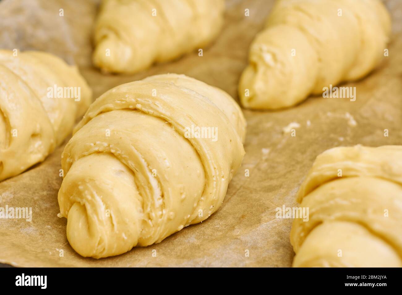 Producing of classic croissants from rolled layered dough. at home. Raw ...