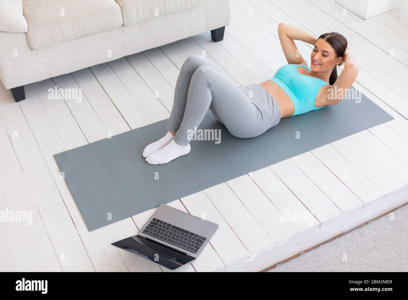 Sporty Woman Doing Abs Exercises Training At Laptop At Home Stock Photo ...
