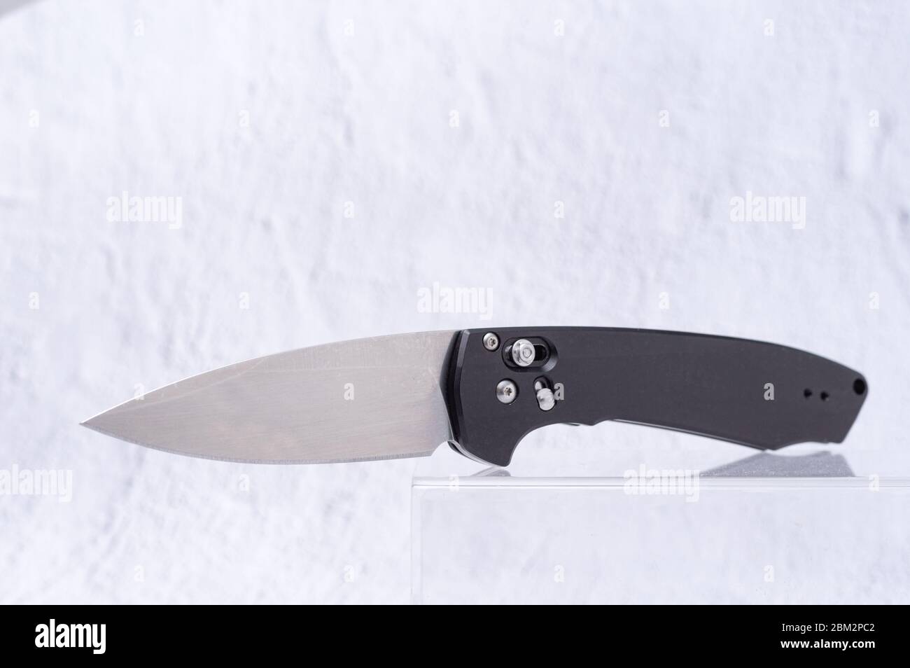 Pocket knife with a mirror-shiny blade and black handle. Knife on a ...