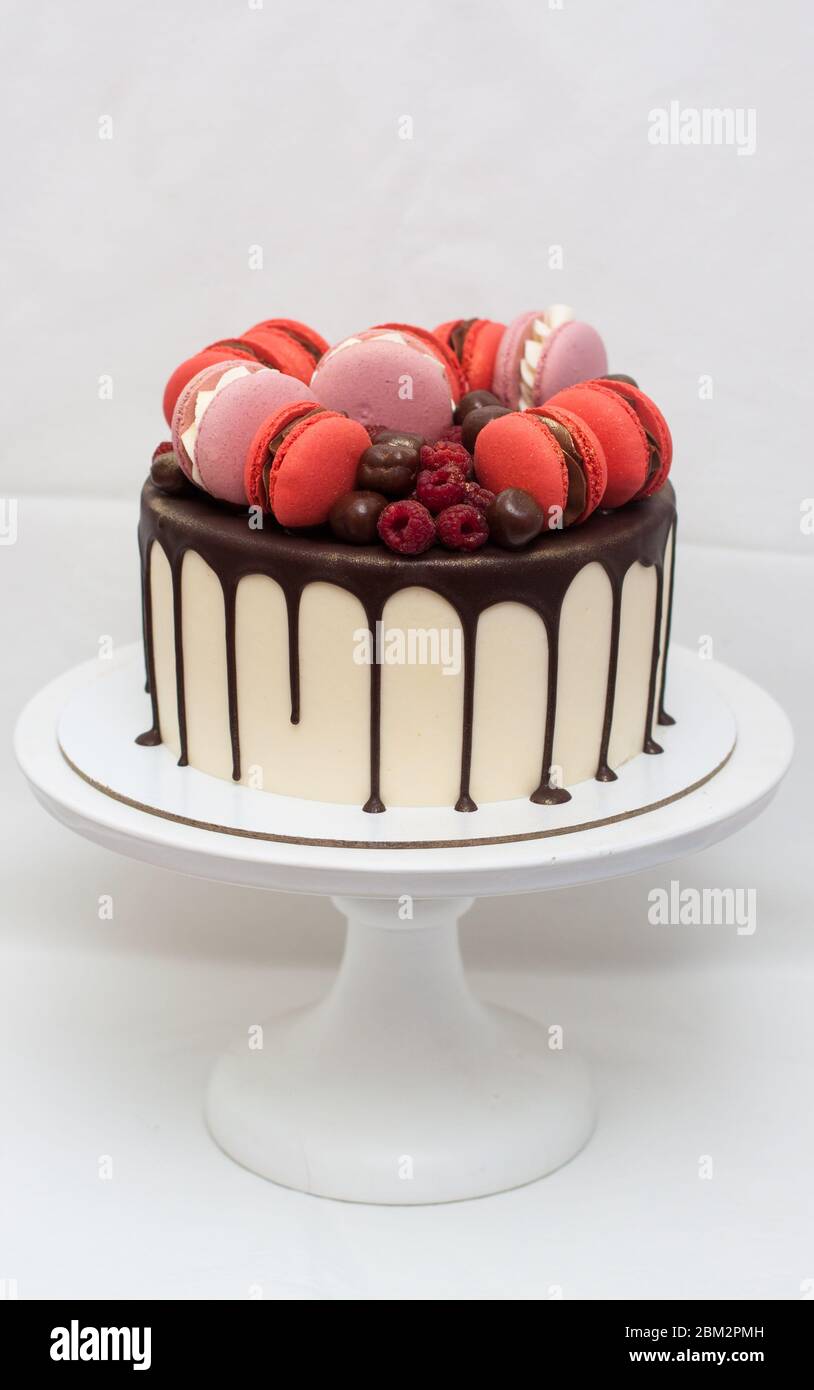 Cake with melted chocolate, red and pink french macaroons, fresh ...