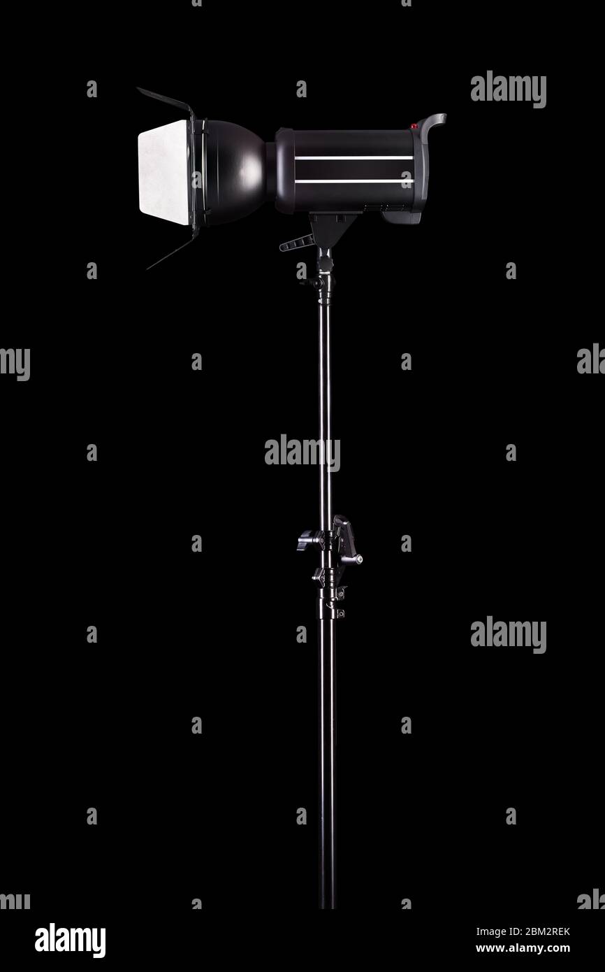 Photography studio flash on a lighting stand isolated on black ...