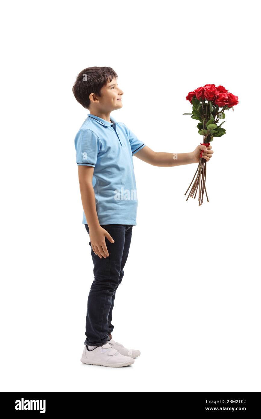 Full length profile shot of a boy holding a bunch of red roses isolated ...