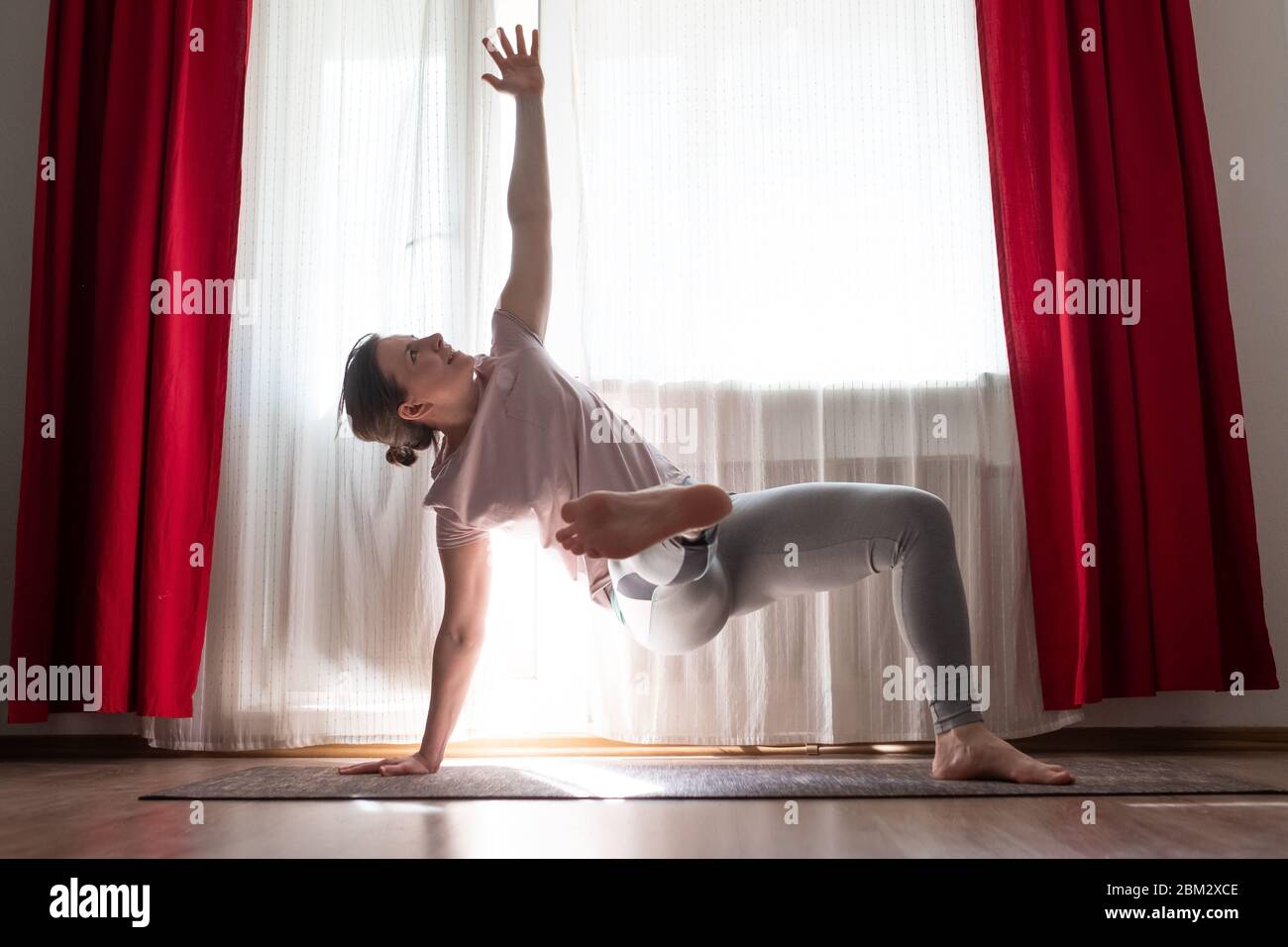 Caucasian woman doing Vasisthasana variation or Side Plank yoga pose ...