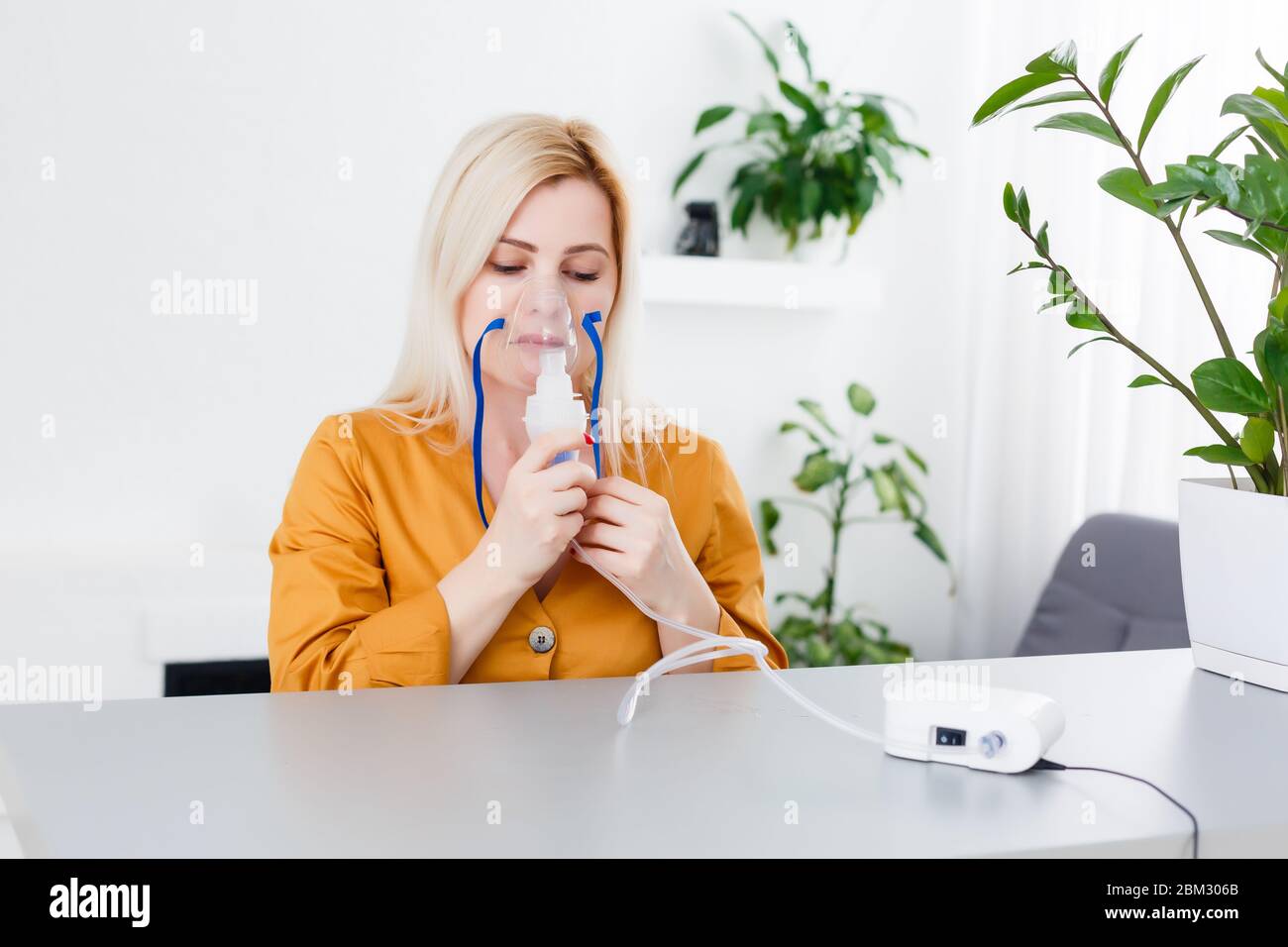 Sick beautiful female holds nasal mask with respiratory problem in ...