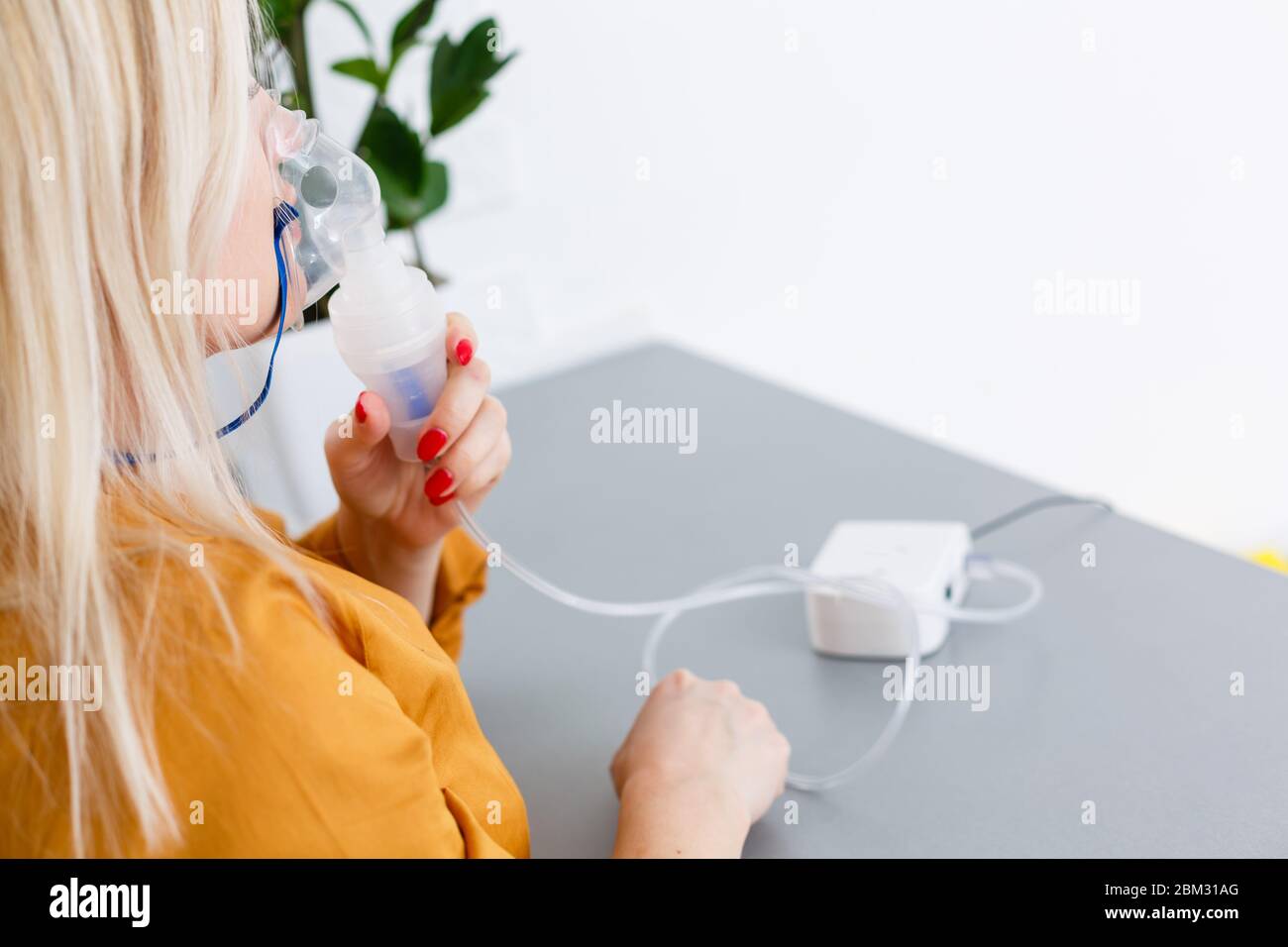 Portrait of adult woman using steam vapor inhaler nebulizer doing ...