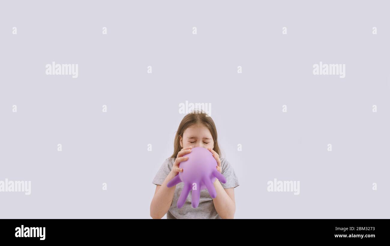 Young sad girl play with protective medical glove. Teenager with glove ...