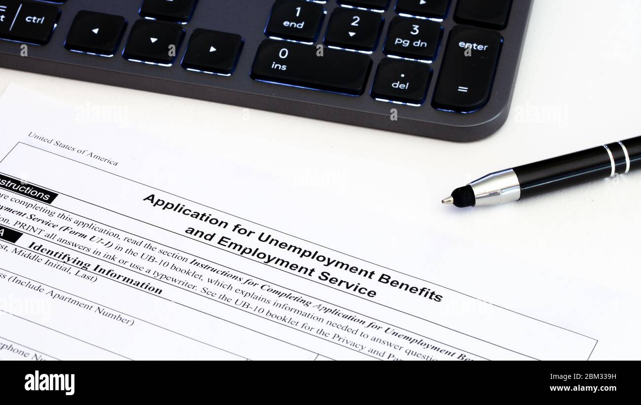 Application for employment benefits form with computer keyboard and pen ...