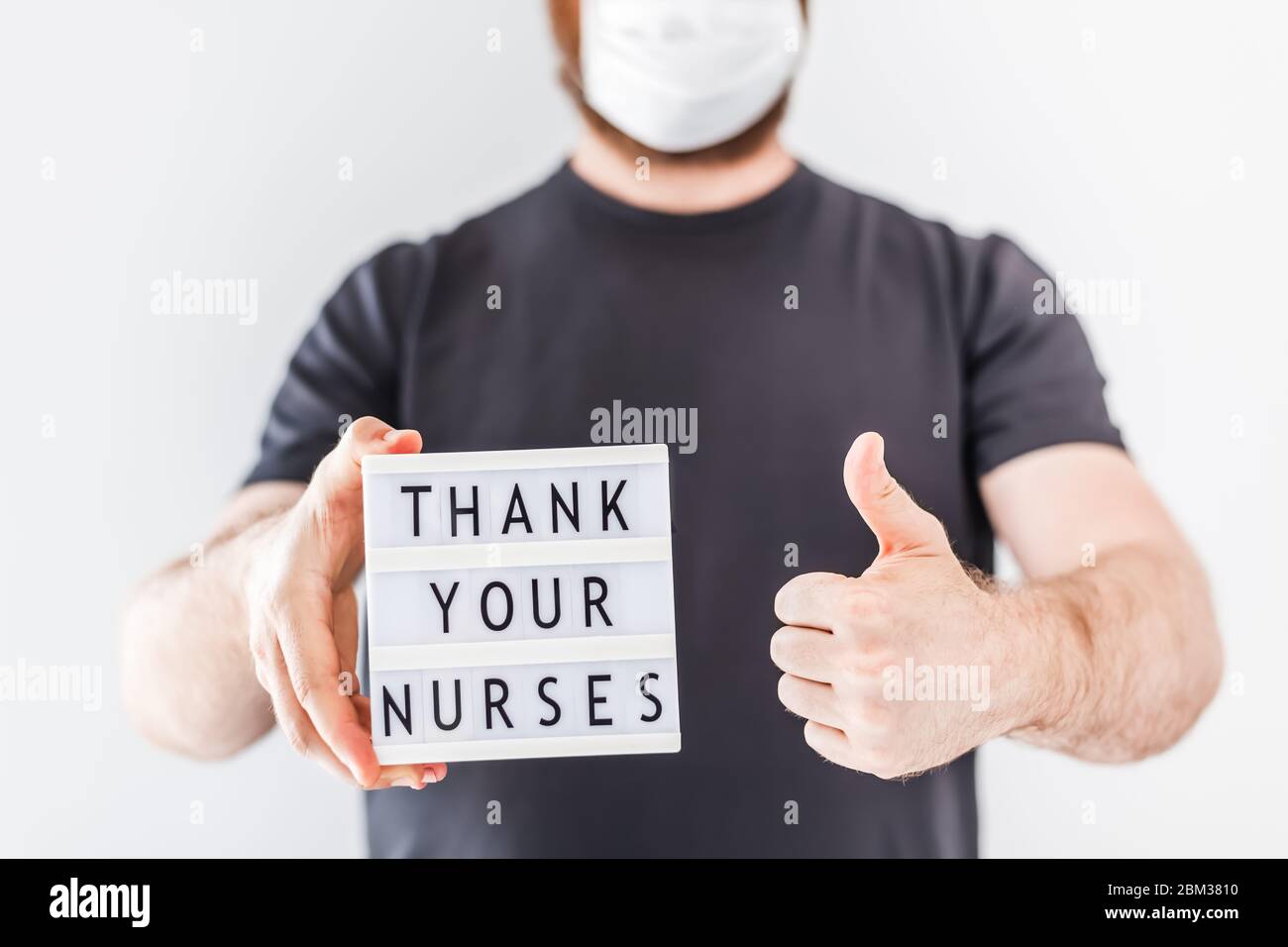 Nurse day concept. Man hands holding lightbox with text Thank your ...
