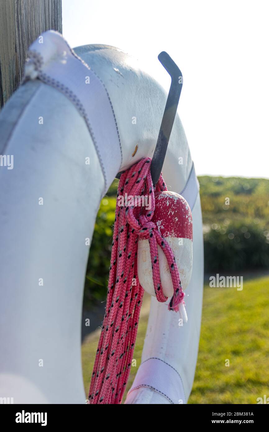 White Nautical Lifesaver hanging on wooden post Stock Photo - Alamy