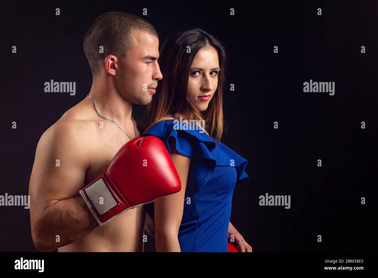 Boxer hugs slender girl on black background Stock Photo - Alamy