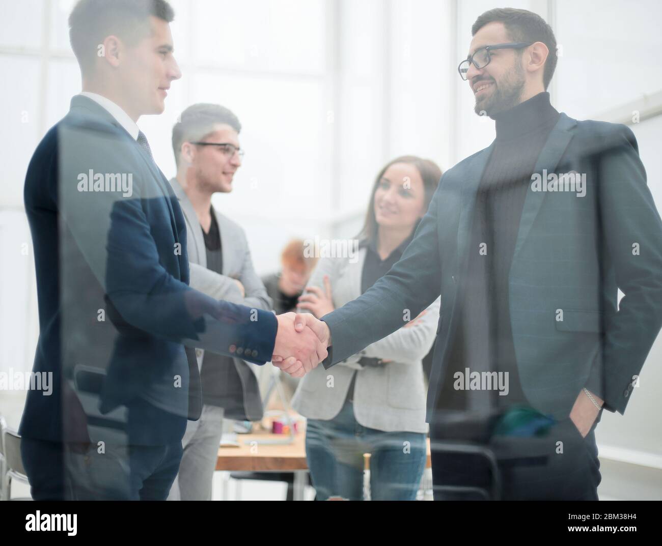 through the glass. business people shaking hands with each other Stock ...