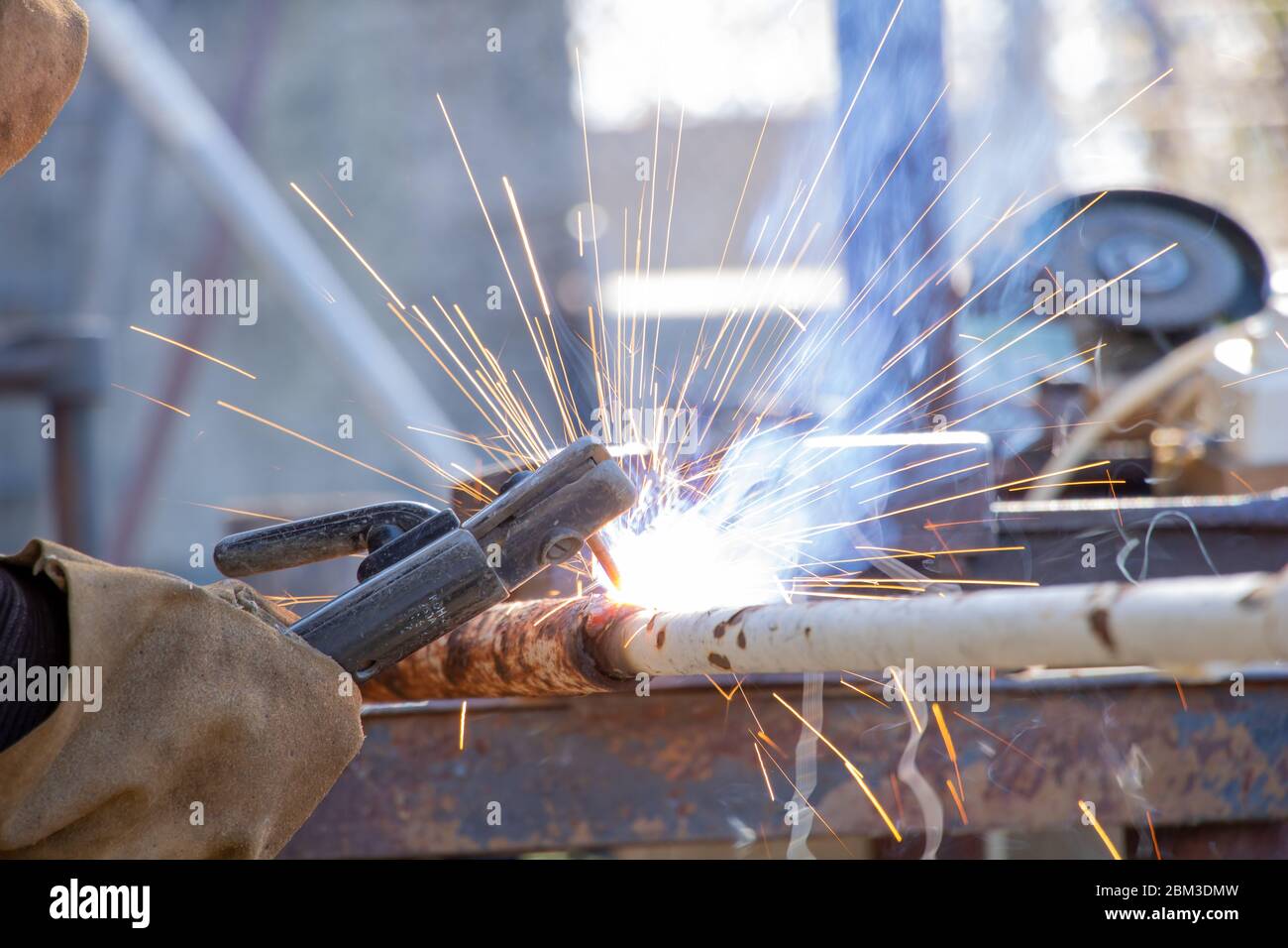 The worker welding metal pipe at the factory Stock Photo - Alamy