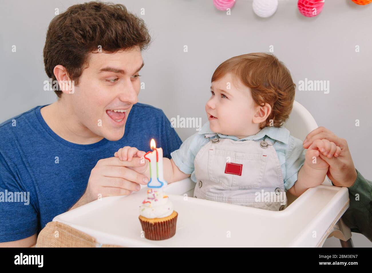 Smiling Caucasian father with baby boy celebrating his first birthday ...