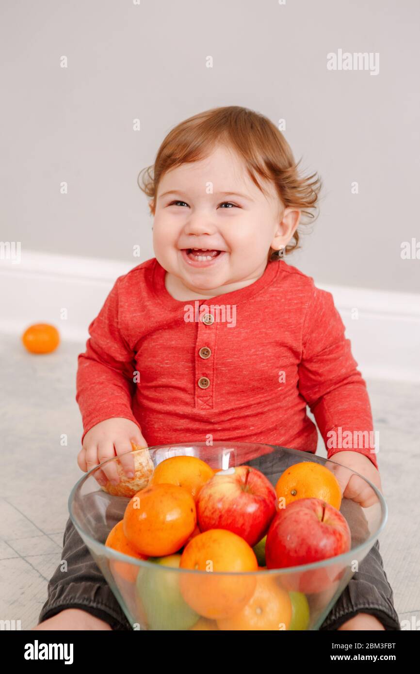 Cute adorable Caucasian baby boy eating citrus fruit. Finny child ...