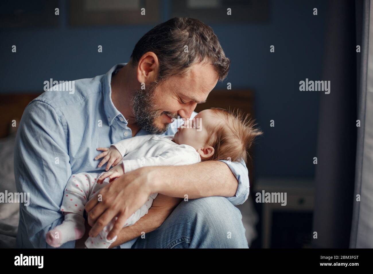 Middle age Caucasian father kissing sleeping newborn baby girl. Parent ...
