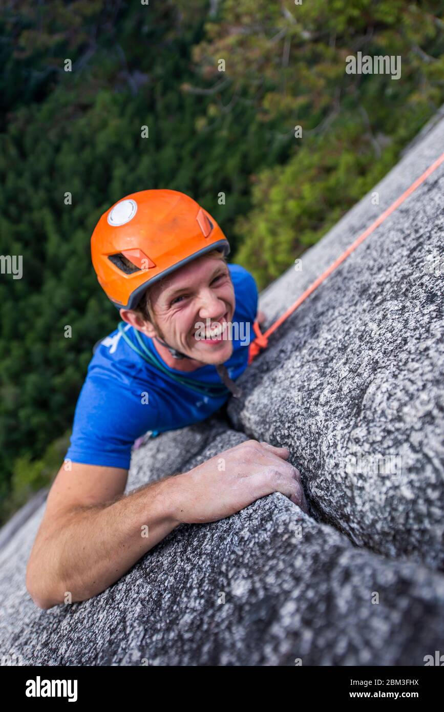 climber looking up and laughing while rock climbing with helmet Chief ...