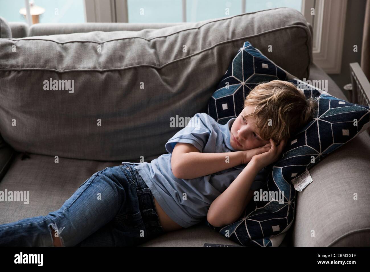 Boy sad on sofa hi-res stock photography and images - Alamy