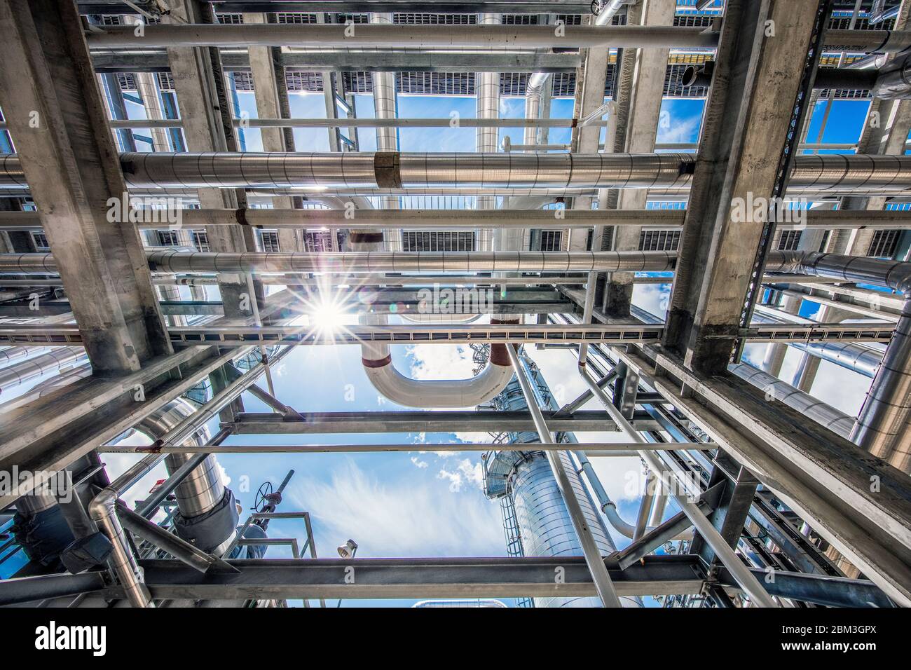 Natural gas processing plant structures with sun flare Stock Photo - Alamy