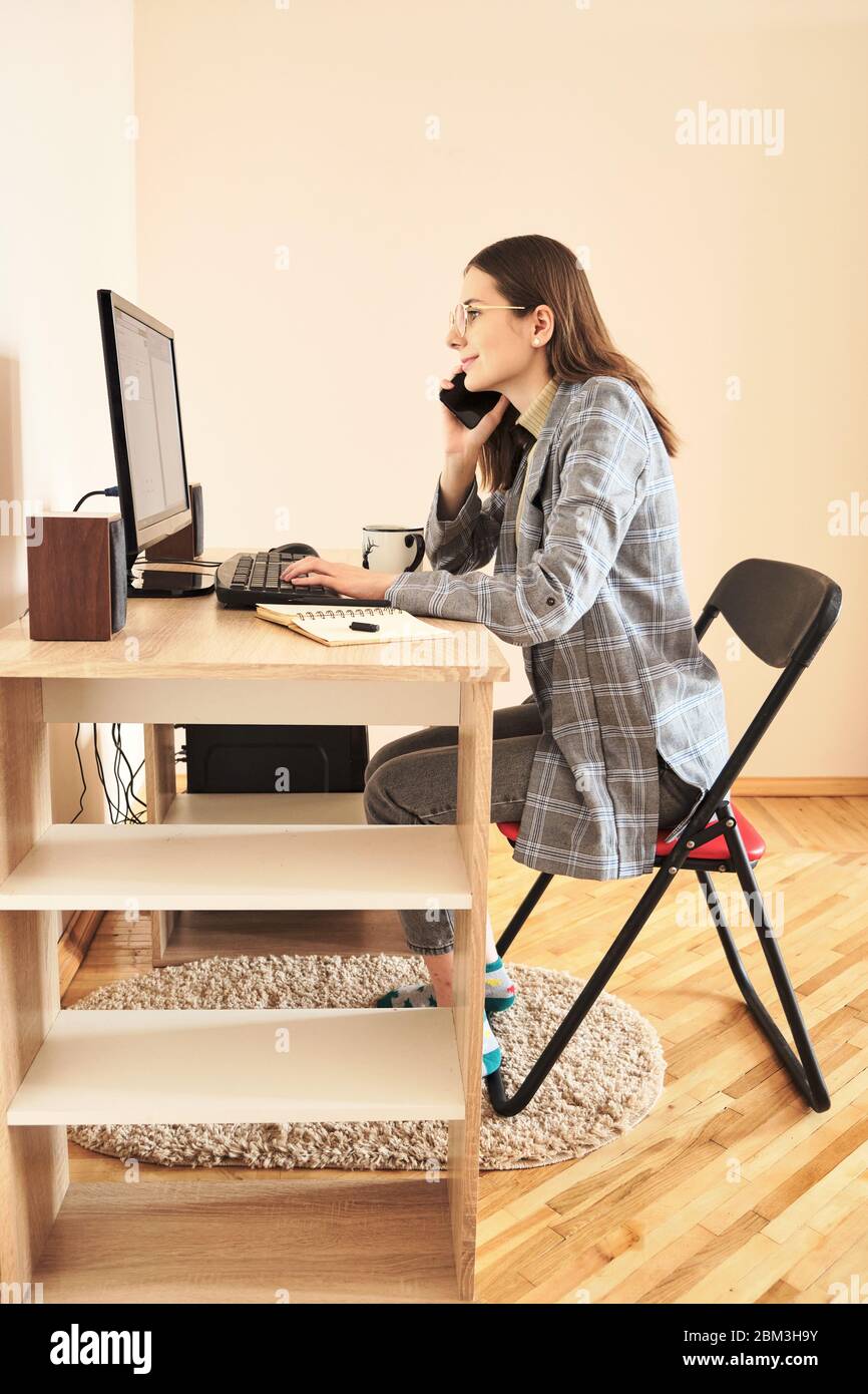 young millennial woman in jacket working at computer at home Stock ...