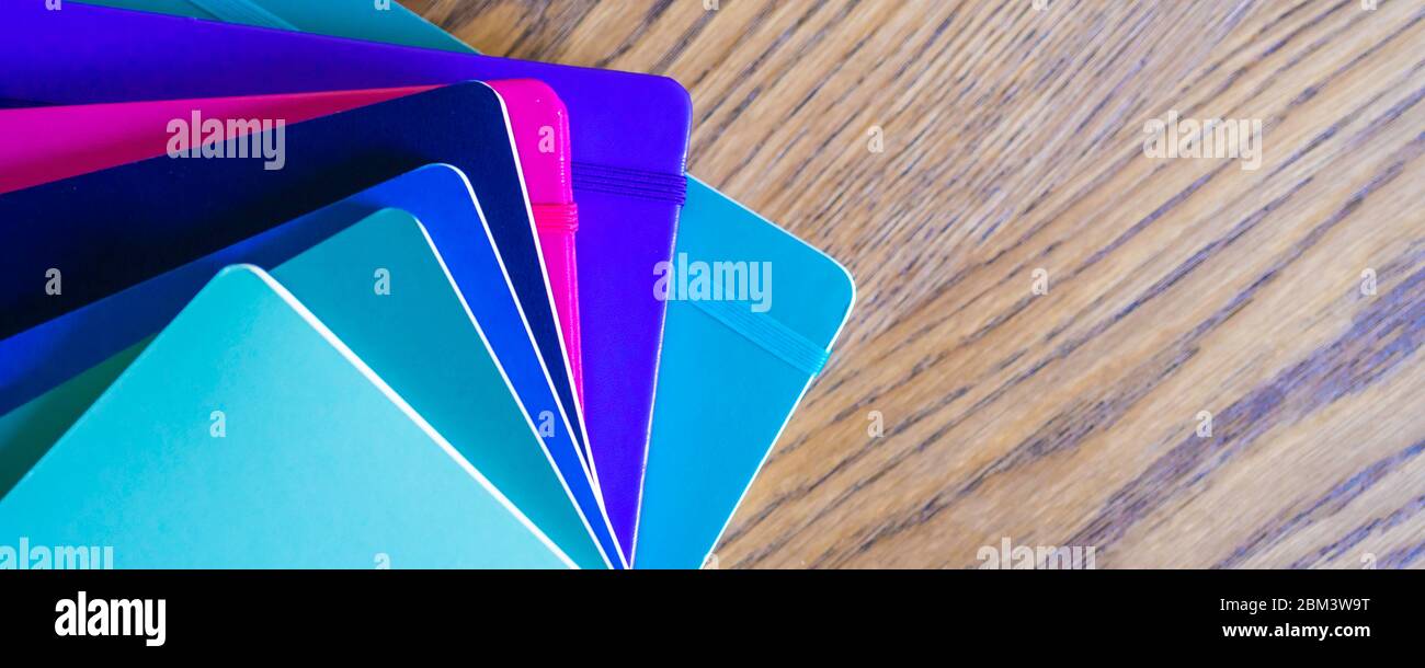 Collection of colored notebooks on office table Stock Photo - Alamy