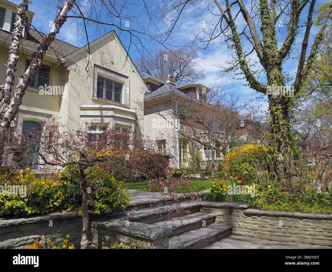 Street of large traditional detached homes with front yards with spring ...
