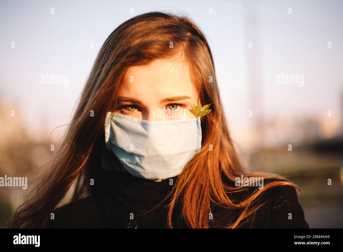 Portrait of anxious teenage girl wearing protective face medical mask ...