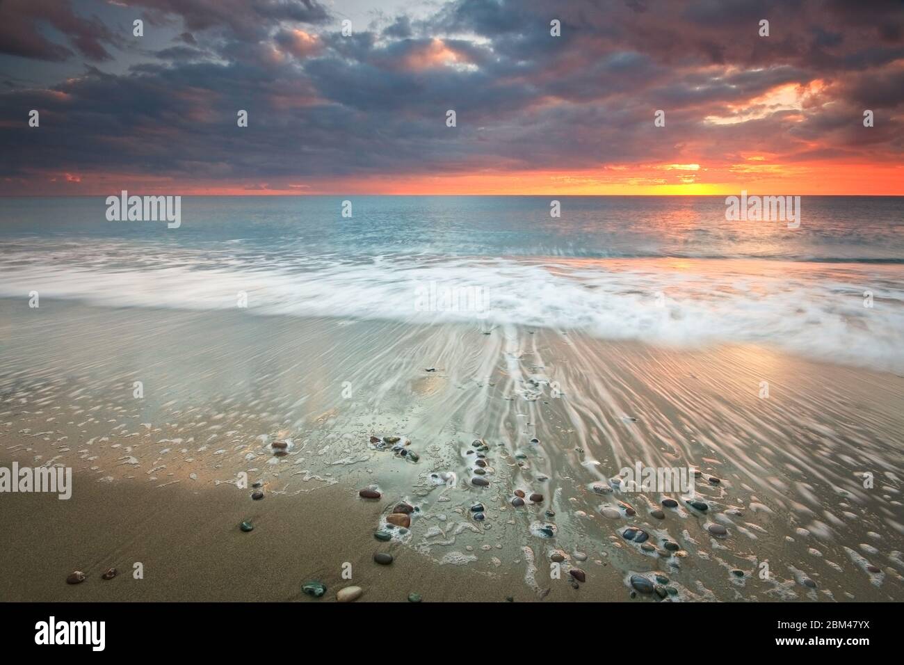 Sunset on a beach in Crete, Greece Stock Photo - Alamy