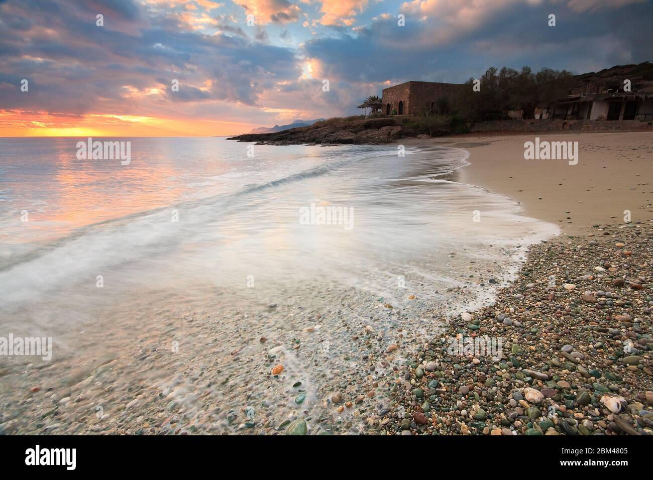 Sunset on a beach in Crete, Greece Stock Photo - Alamy