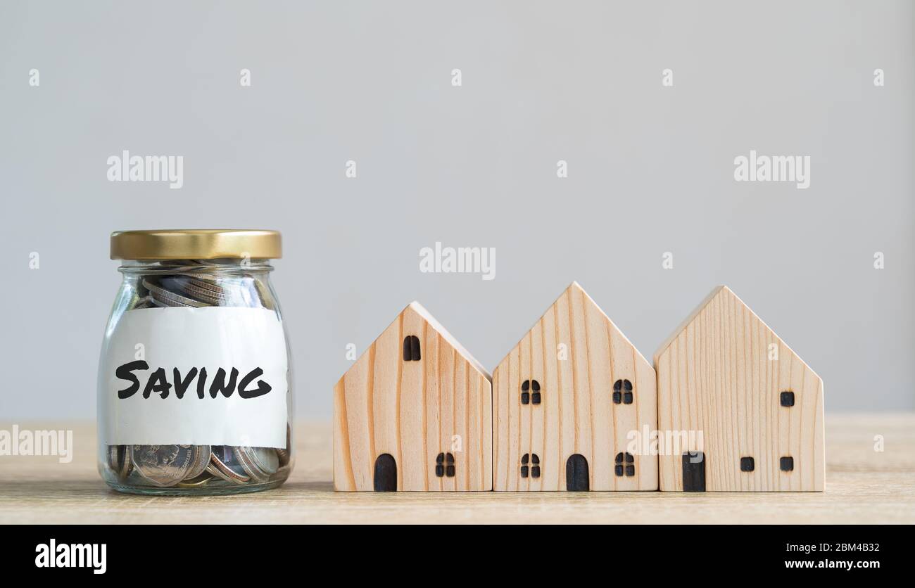 Money savings concepts. Wooden house models with coins in bottle and ...
