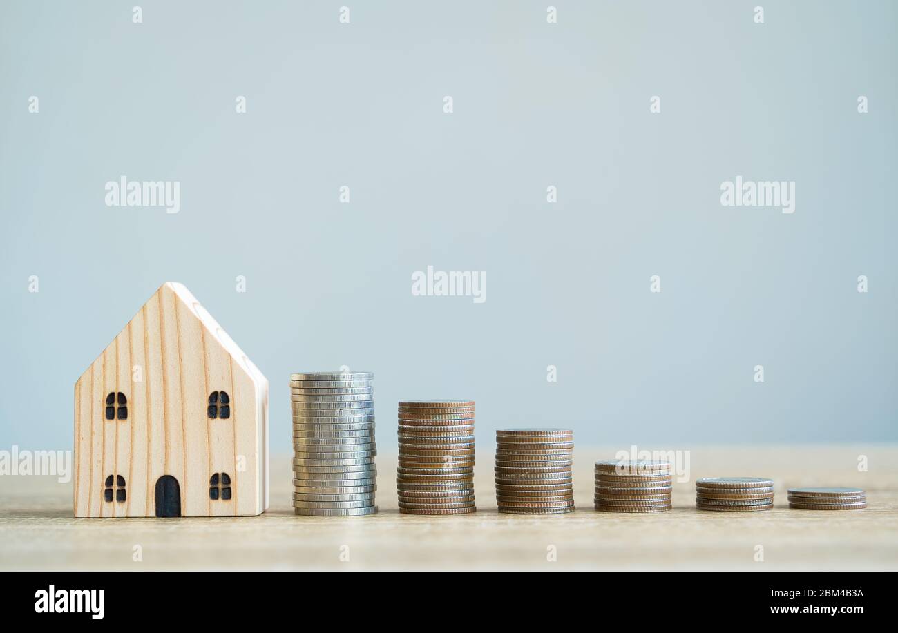 Money savings concepts. Wooden house models with stacked coins in ...
