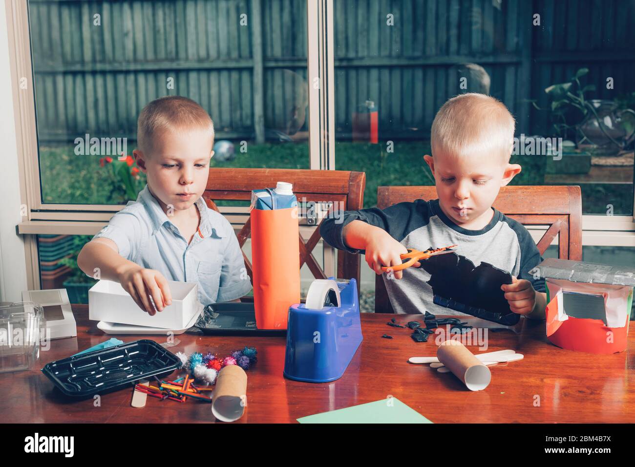 Little boys making crafts from different recycled materials and playing ...