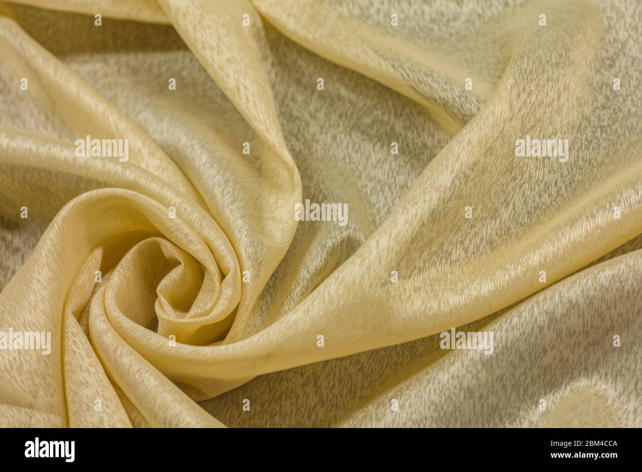Creased beige curved cloth material fragment with swirl as fabric ...