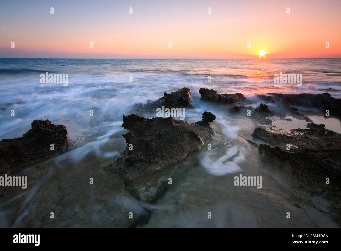 Sunset on a beach in Crete, Greece Stock Photo - Alamy