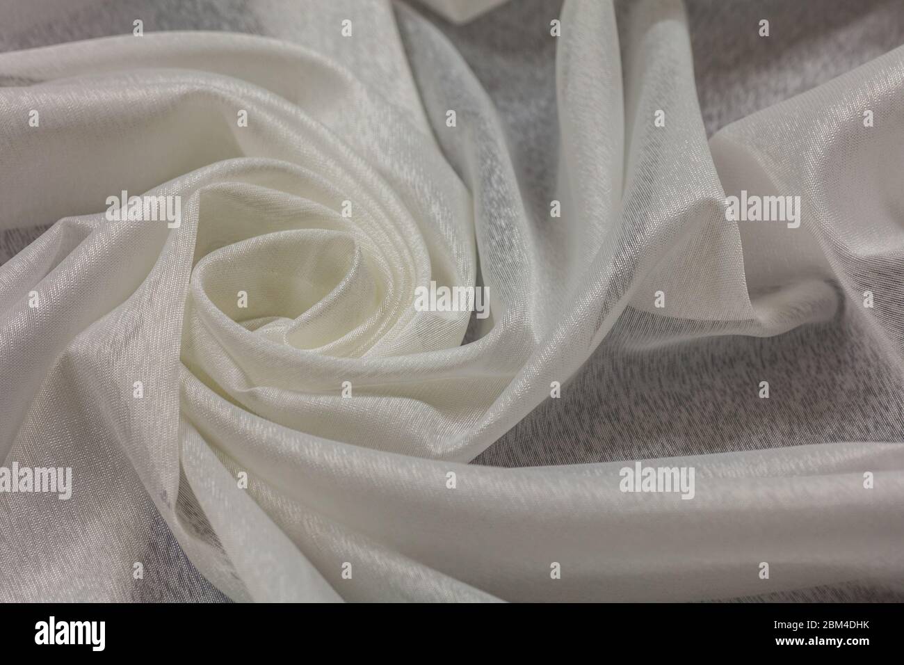 Creased white curved cloth material fragment with swirl as fabric ...