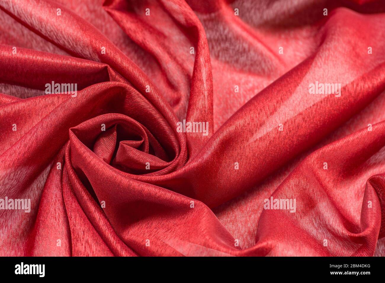 Creased red curved cloth material fragment with swirl as fabric ...
