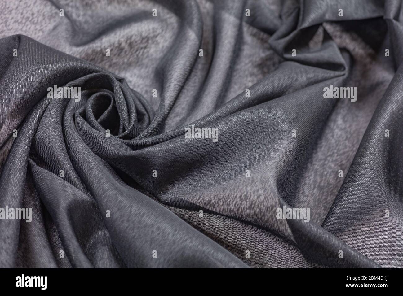 Creased black curved cloth material fragment with swirl as fabric ...