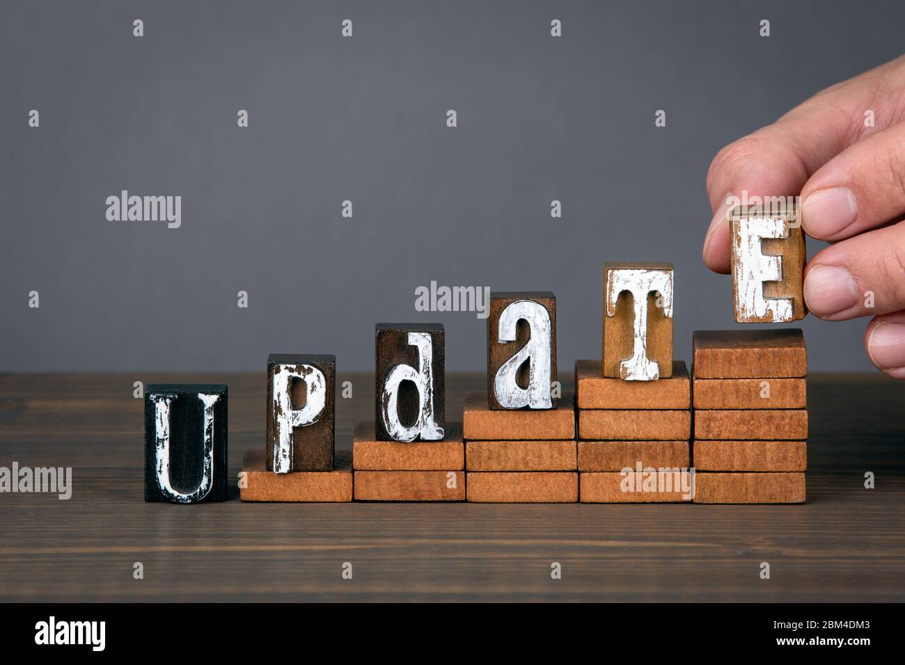 UPDATE concept. Wooden alphabet letters on steps. Gray background Stock ...